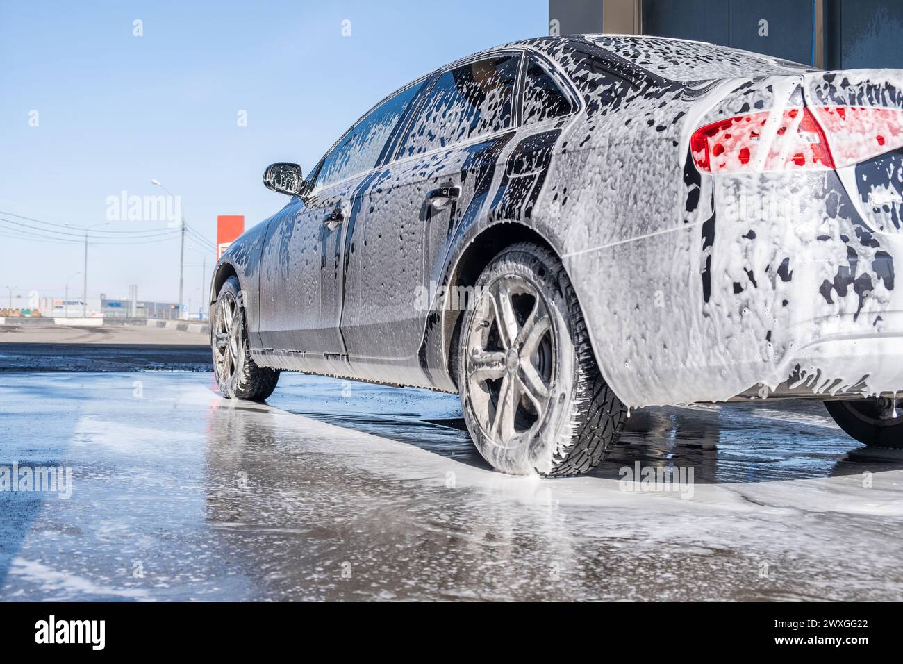 Foamy car at car wash, with tire, wheel, and hood covered in suds Stock ...