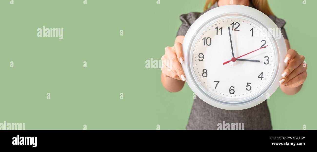 Businesswoman with clock on green background with space for text. Time ...
