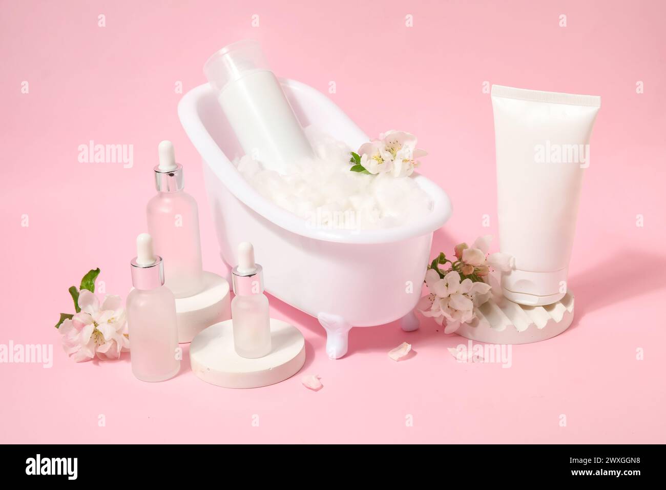 Composition with mini bathtub, bottles of cosmetic products and flowers ...