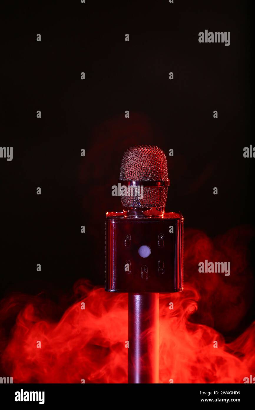 Modern microphone and red smoke on dark background Stock Photo - Alamy