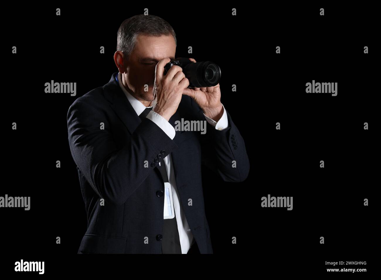 Mature FBI agent with photo camera on black background Stock Photo - Alamy