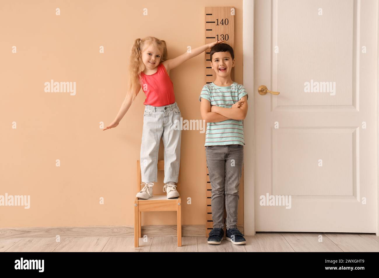 Cute little kids measuring height near wooden stadiometer Stock Photo ...