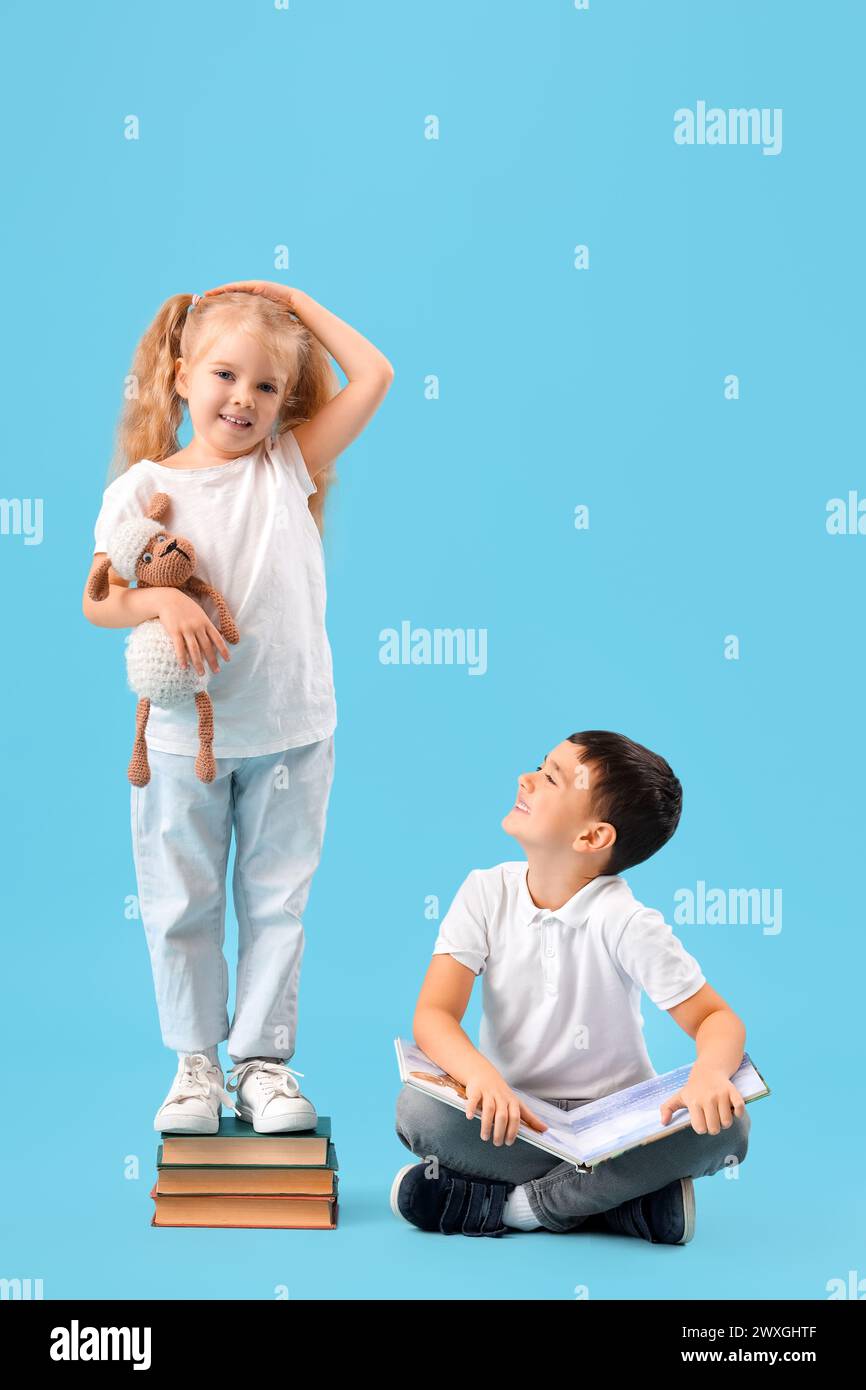 Cute little kids measuring height on blue background Stock Photo - Alamy