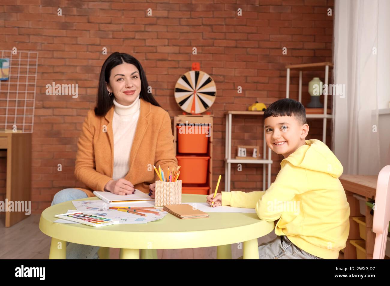 Little boy with psychologist drawing during art therapy in office Stock ...