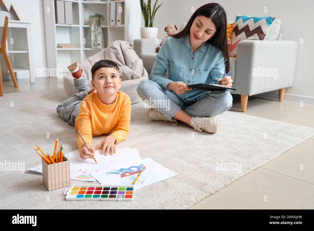 Little boy with psychologist drawing in office Stock Photo - Alamy