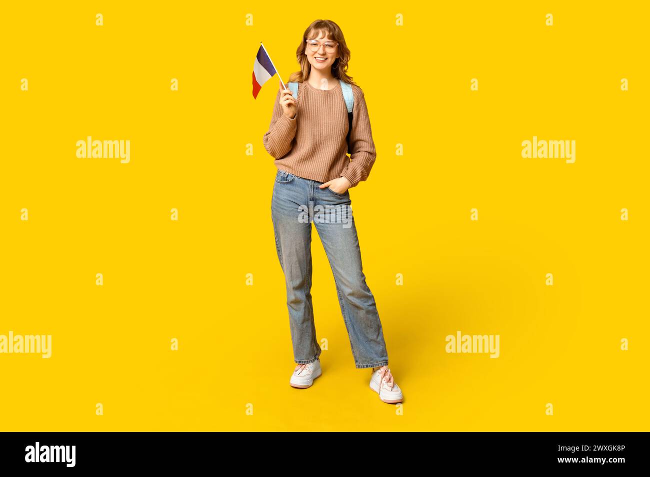 Female student with French flag on yellow background Stock Photo - Alamy