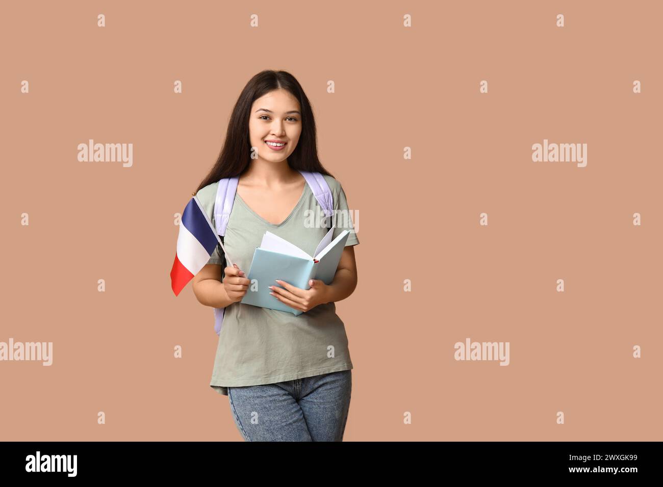 Female student with French flag and open book on beige background Stock ...