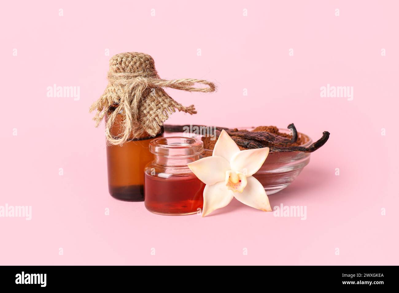 Composition with vanilla extract, sticks and cocoa powder on pink ...