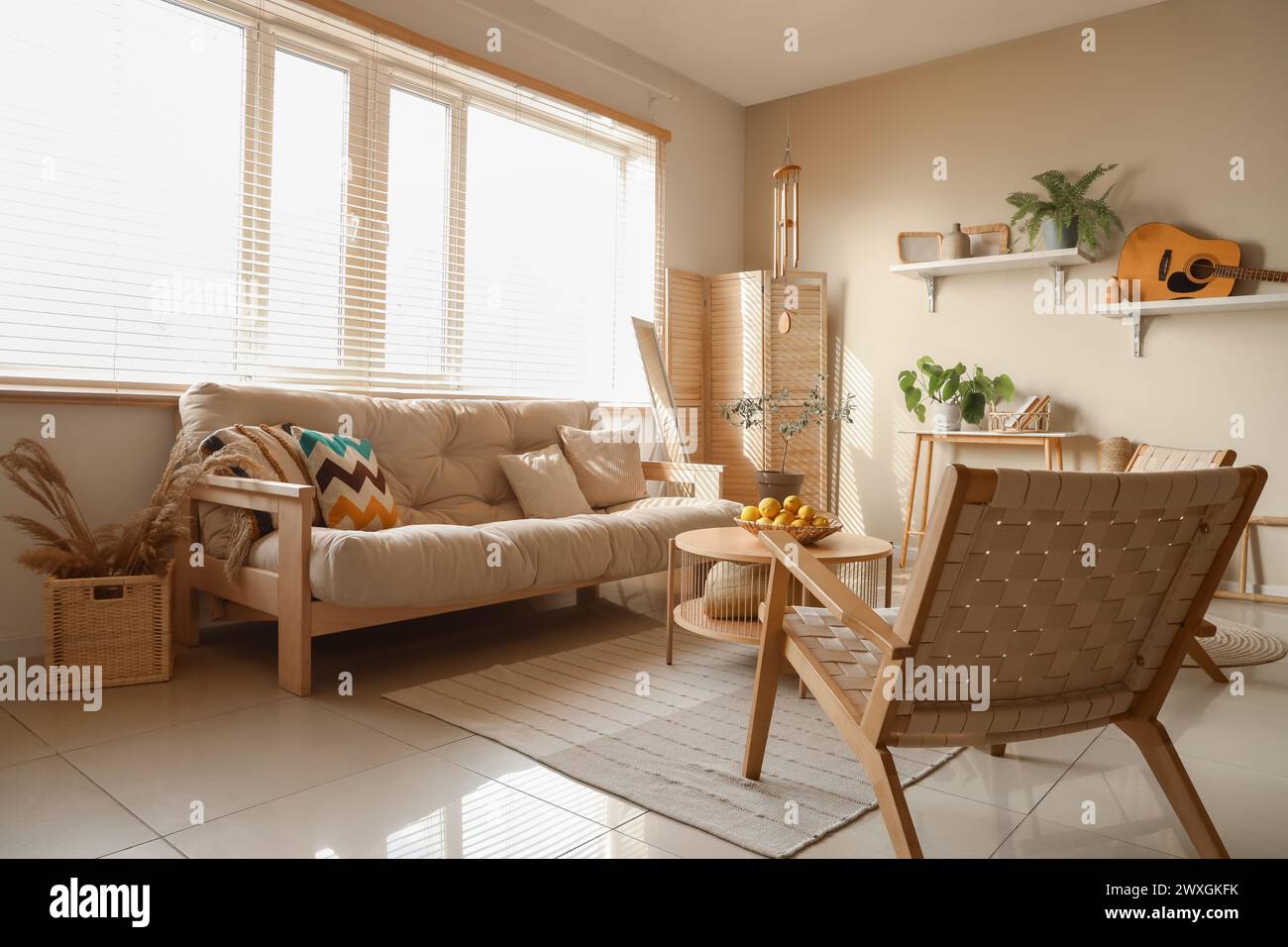 Interior of light living room with wind chime, sofa and armchairs Stock ...