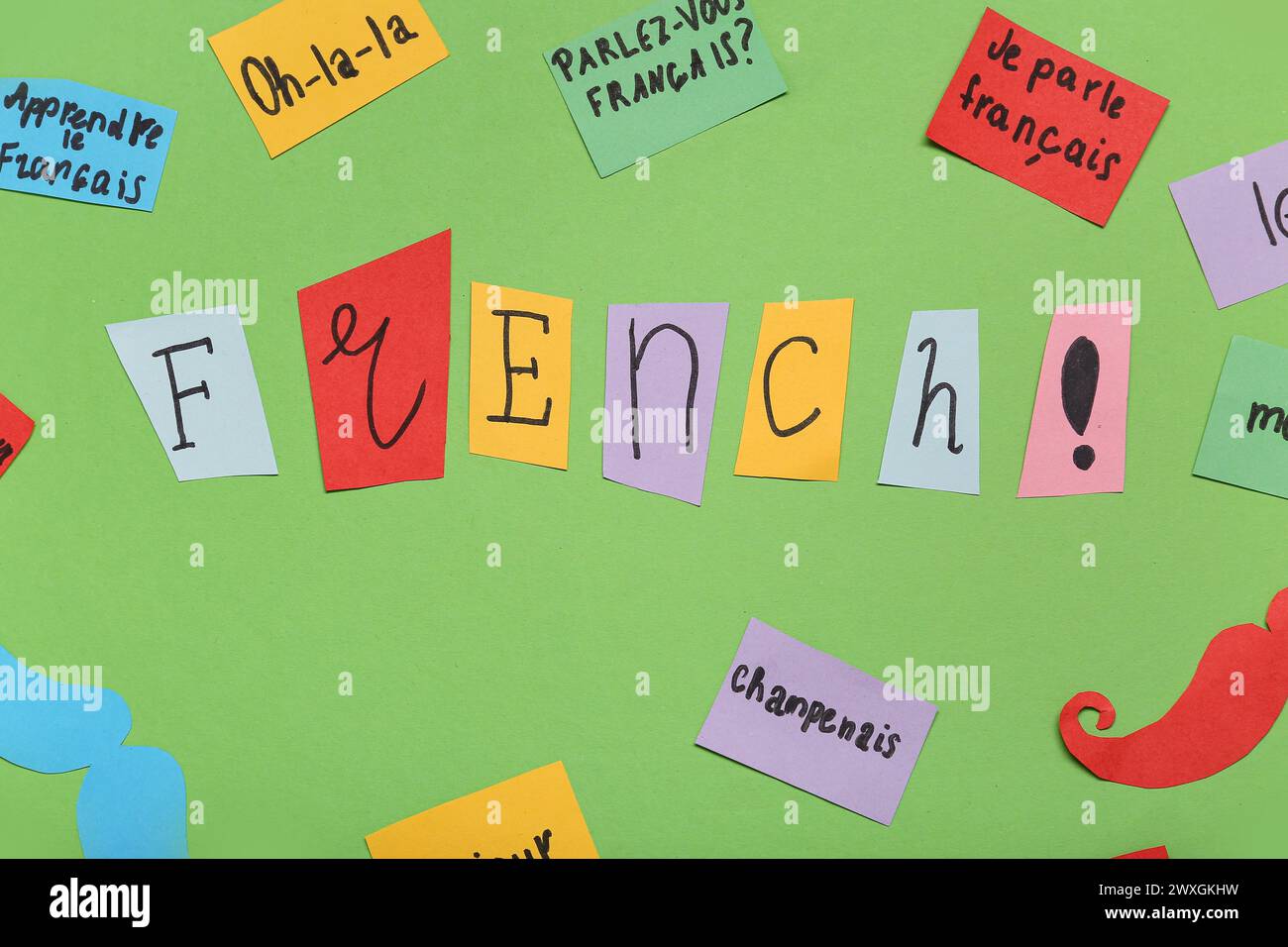 Colorful paper sheets with different French words on green background ...