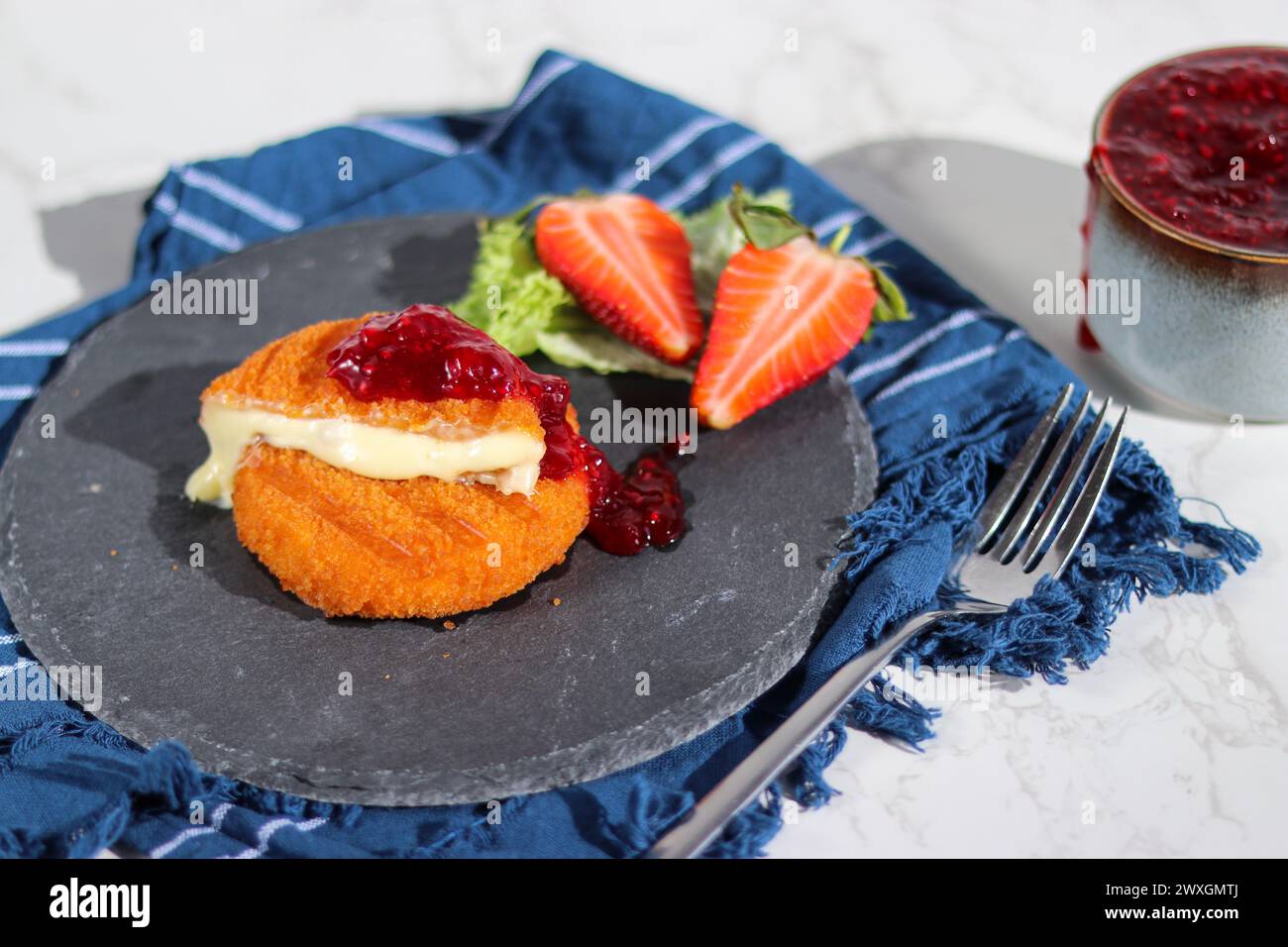 Fresh made fried camembert cheese with cranberry sauce on top, grey ...