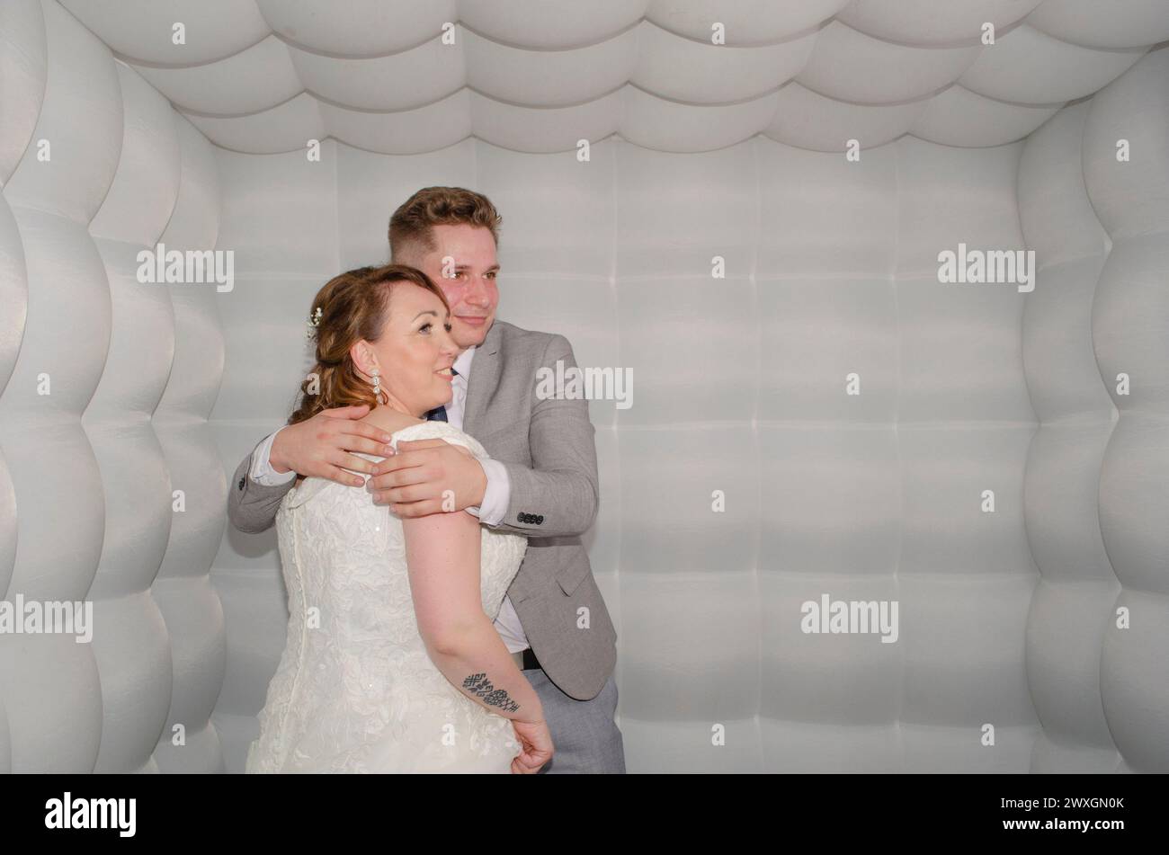 Group of people in a photo booth wearing colourful props, hats, and ...