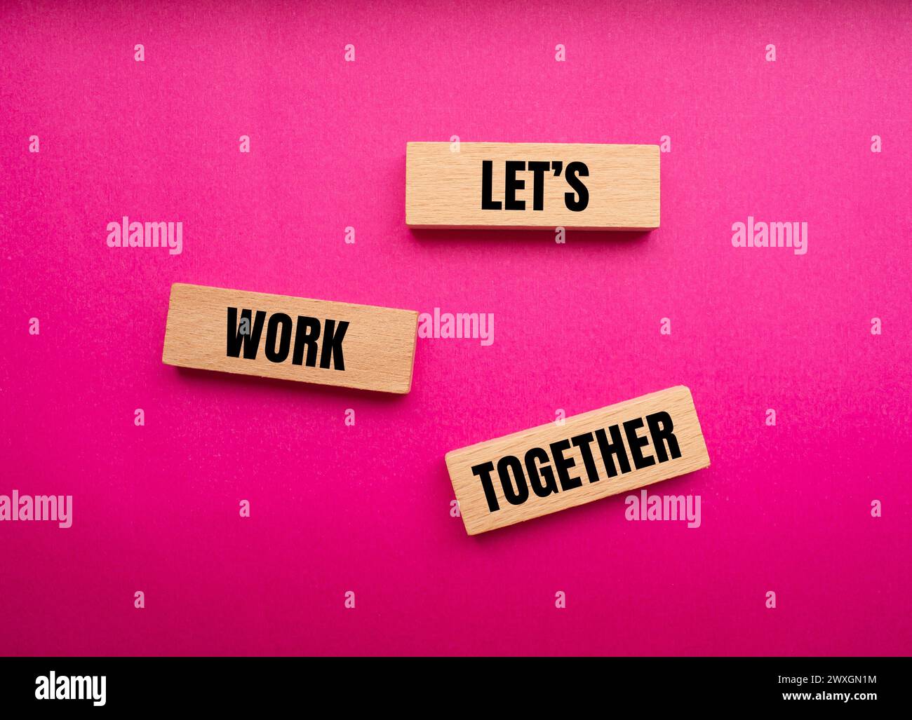 Let's work together words written on wooden blocks with pink background ...