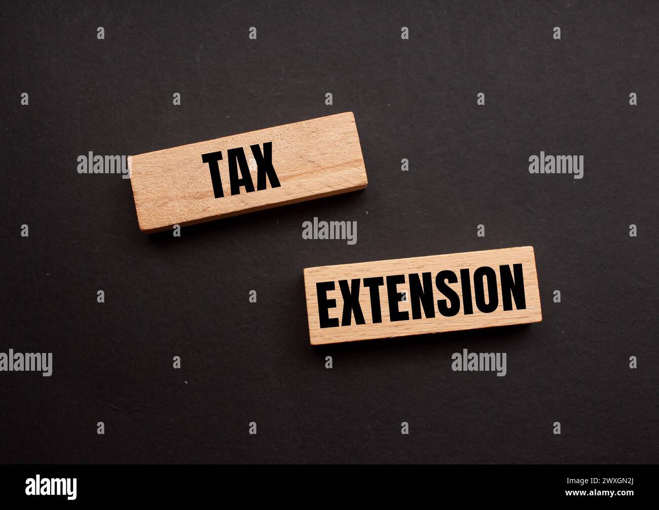 Tax extension words written on wooden blocks with black background ...