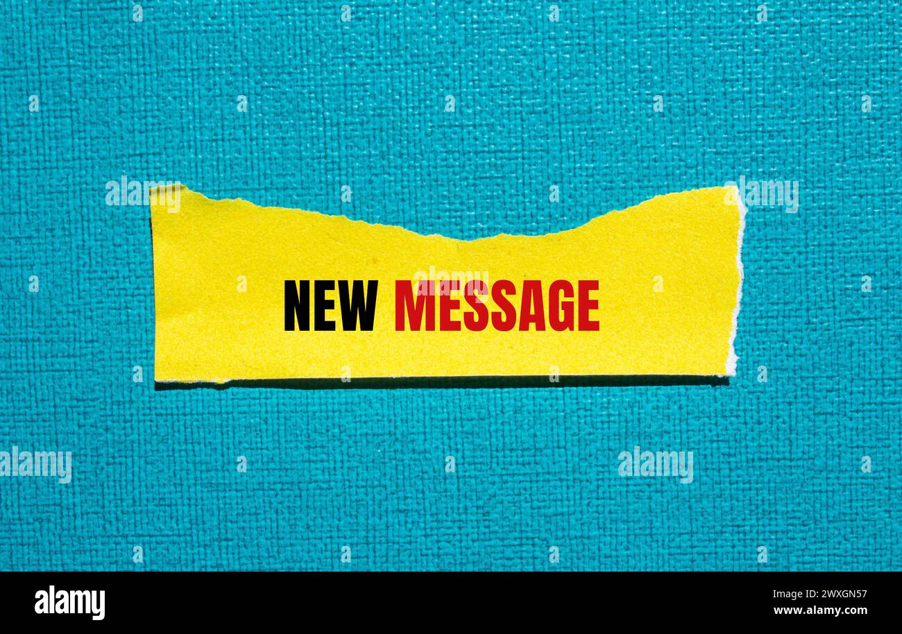 New message words written on yellow torn paper piece with blue ...
