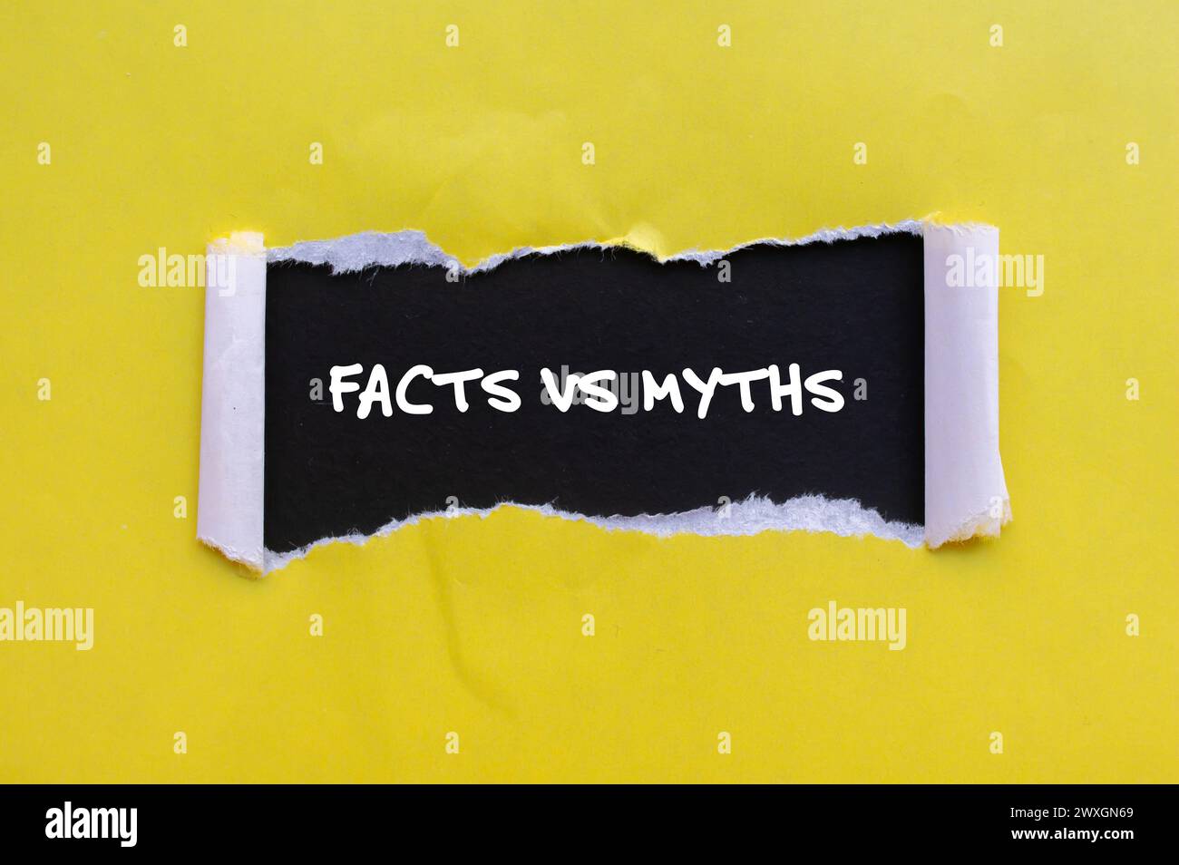 Facts vs myths words written on yellow torn paper with black background ...