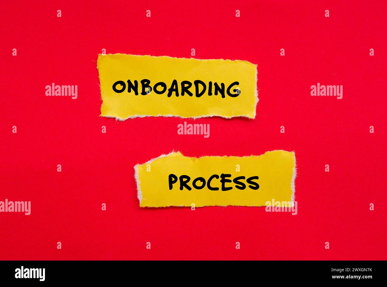 Onboarding process words written on yellow torn paper pieces with red ...