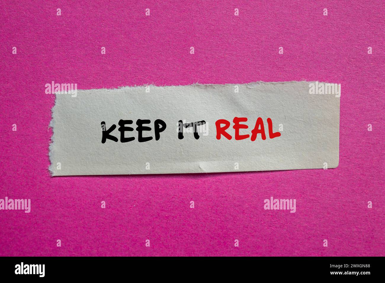 Keep it real words written on torn paper piece with pink background ...