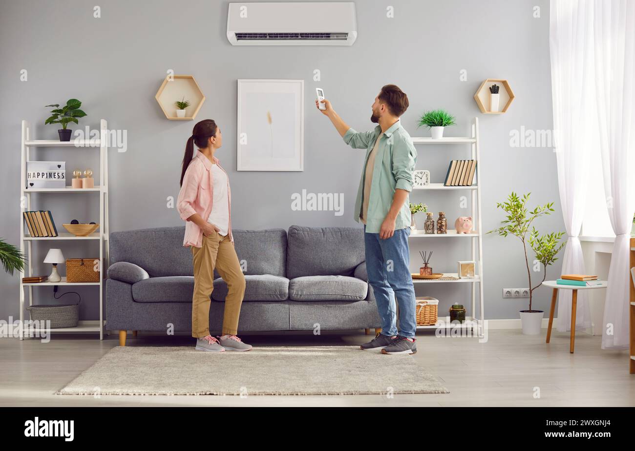 Couple at home enjoys comfort of climate control using modern wall ...
