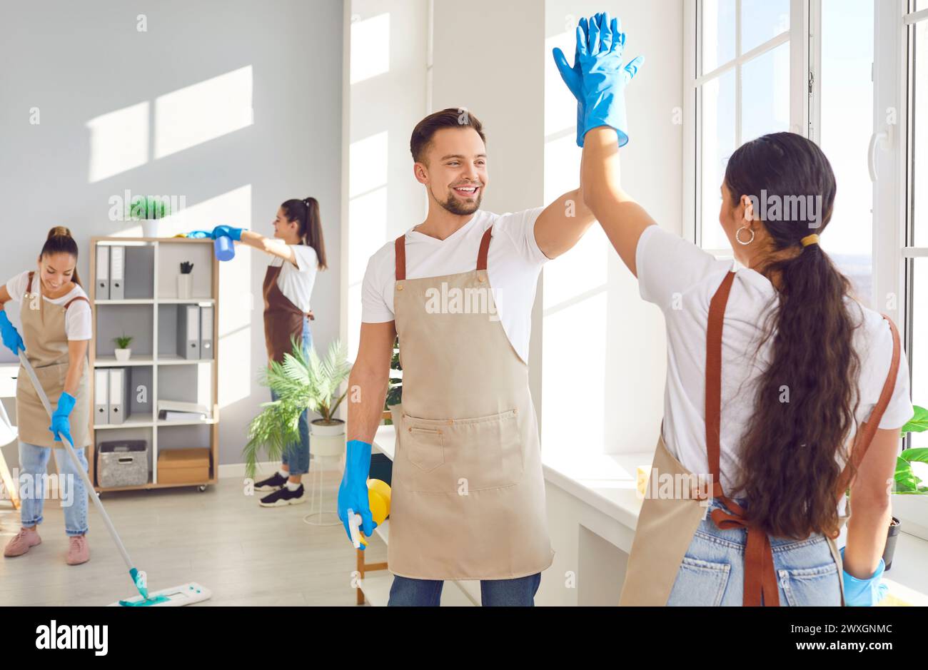 Cleaner Staff Giving High Five While Cleaning A Home Or Office Stock ...