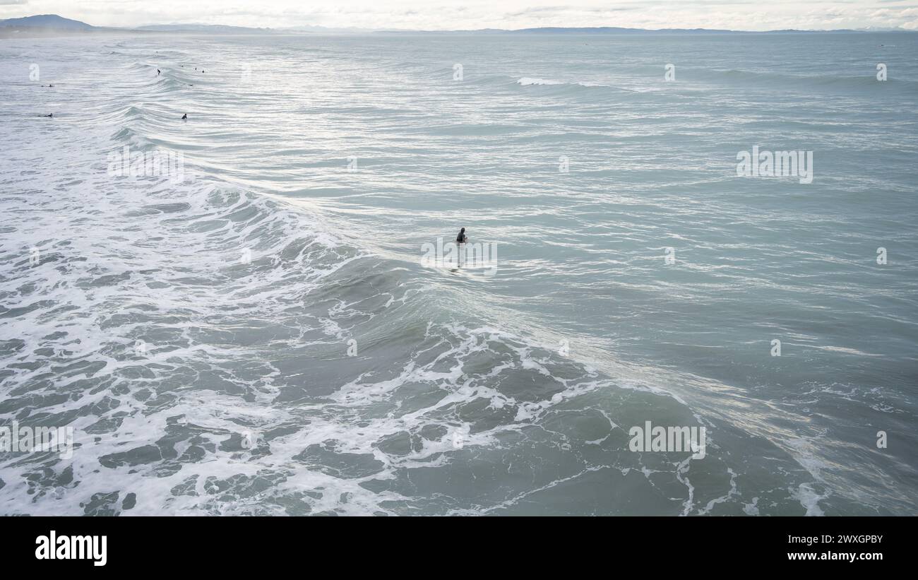 Surfers in rough ocean water waiting to catch approaching waves, New ...