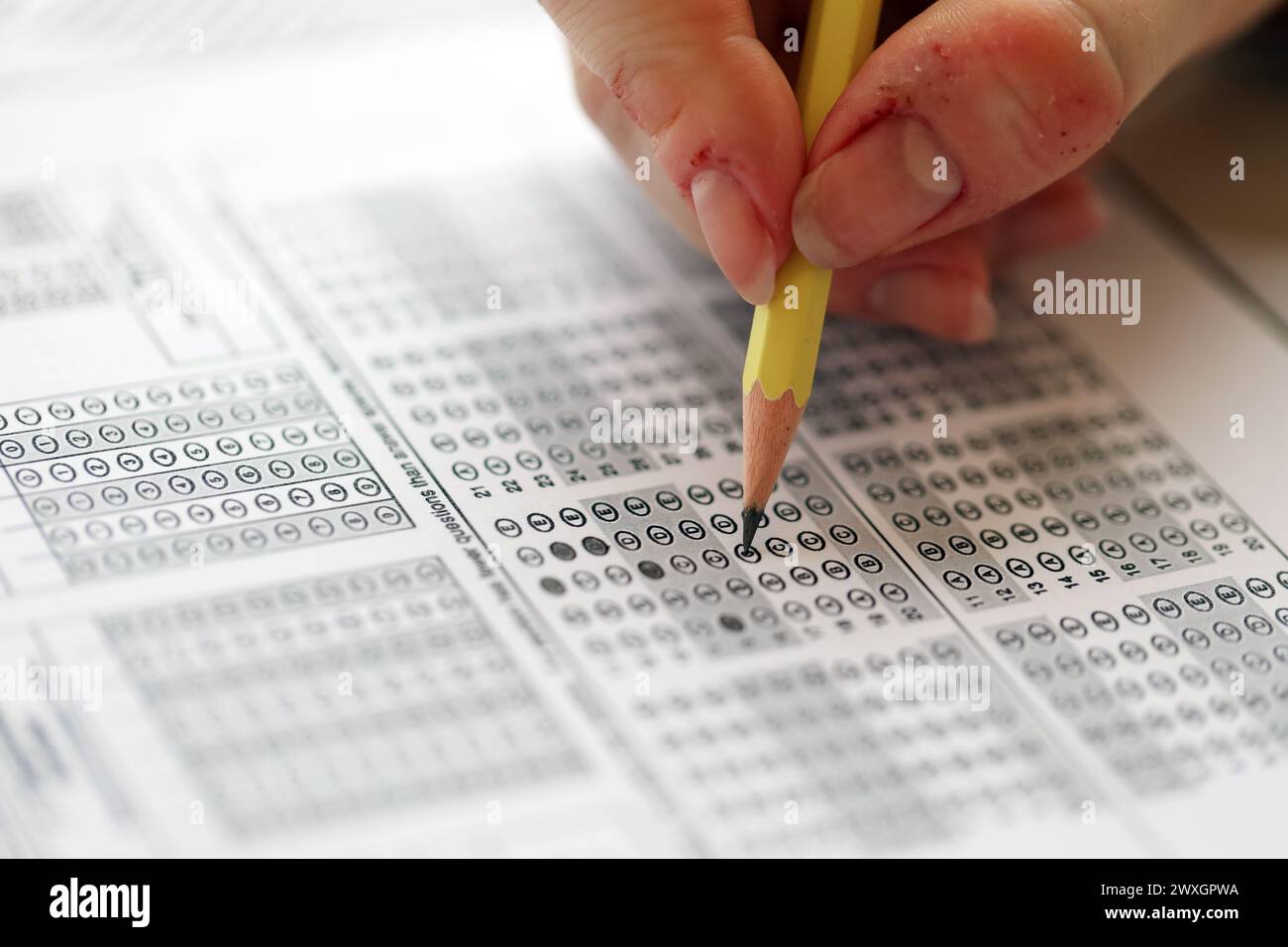 Female student hands testing in exercise and taking fill in exam paper ...