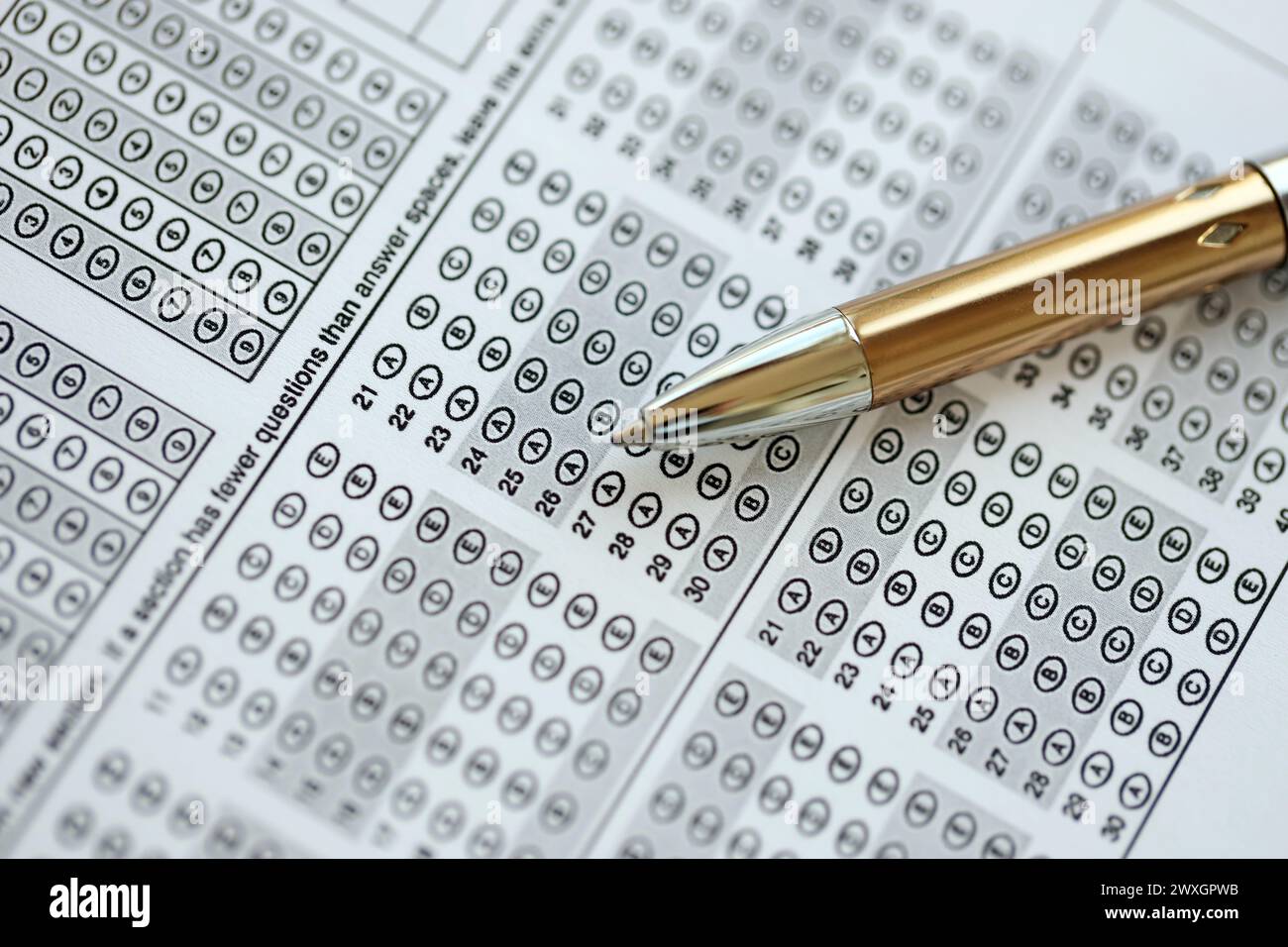 Blank educational test for students lies on table in classroom with pen ...
