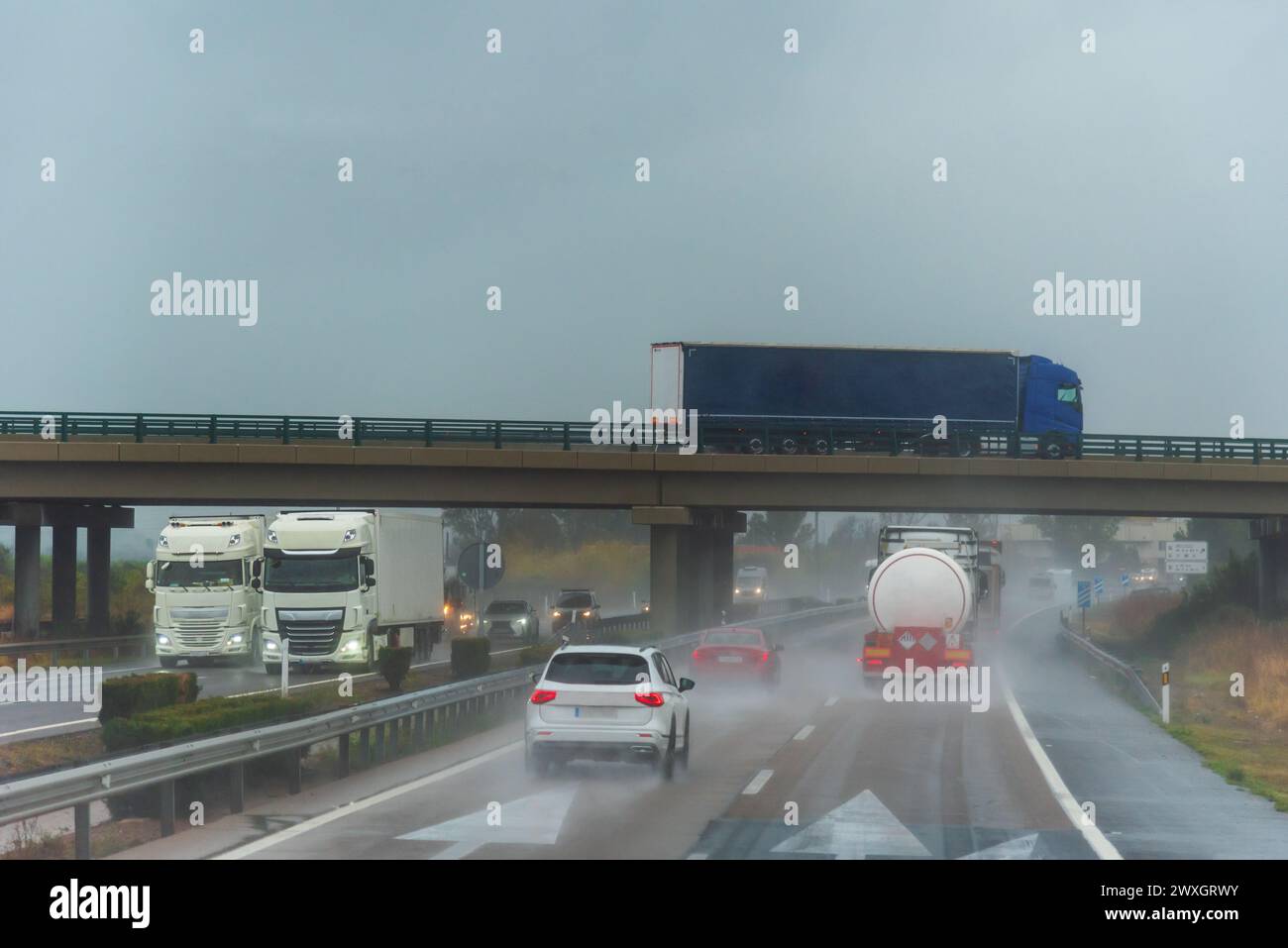 Highway with many cars and trucks circulating on a day of heavy rain ...