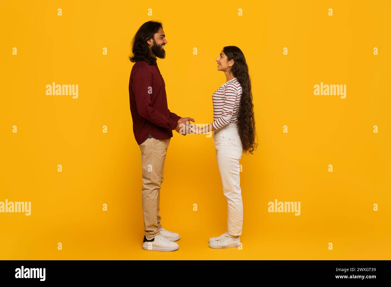 Couple holding hands facing each other Stock Photo - Alamy