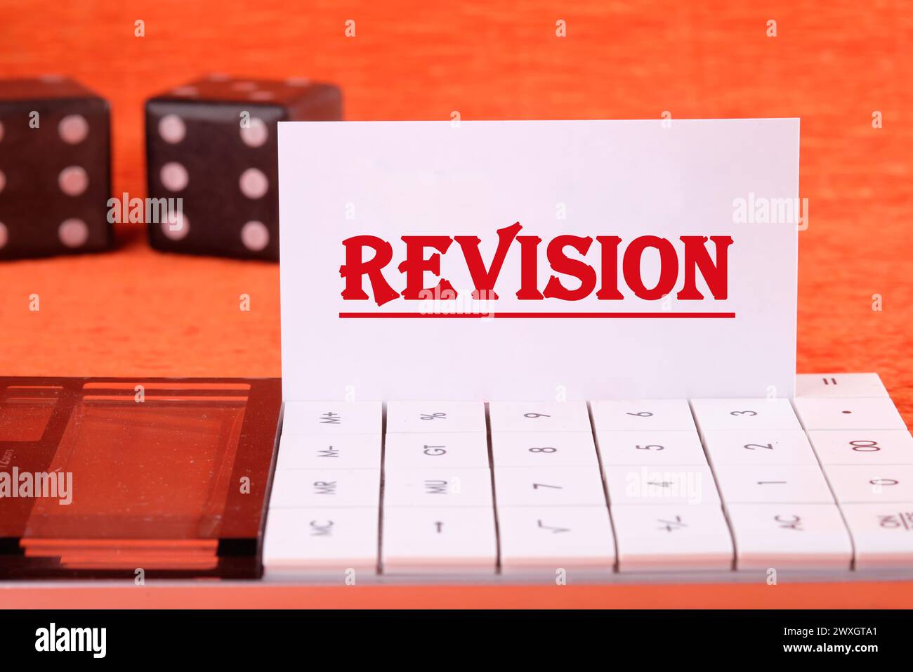 Revision word on a white business card on a calculator on an orange ...