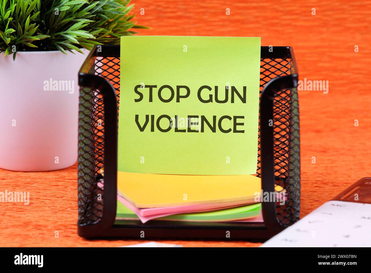 STOP GUN VIOLENCE text on a sticker in a stand on an orange background ...