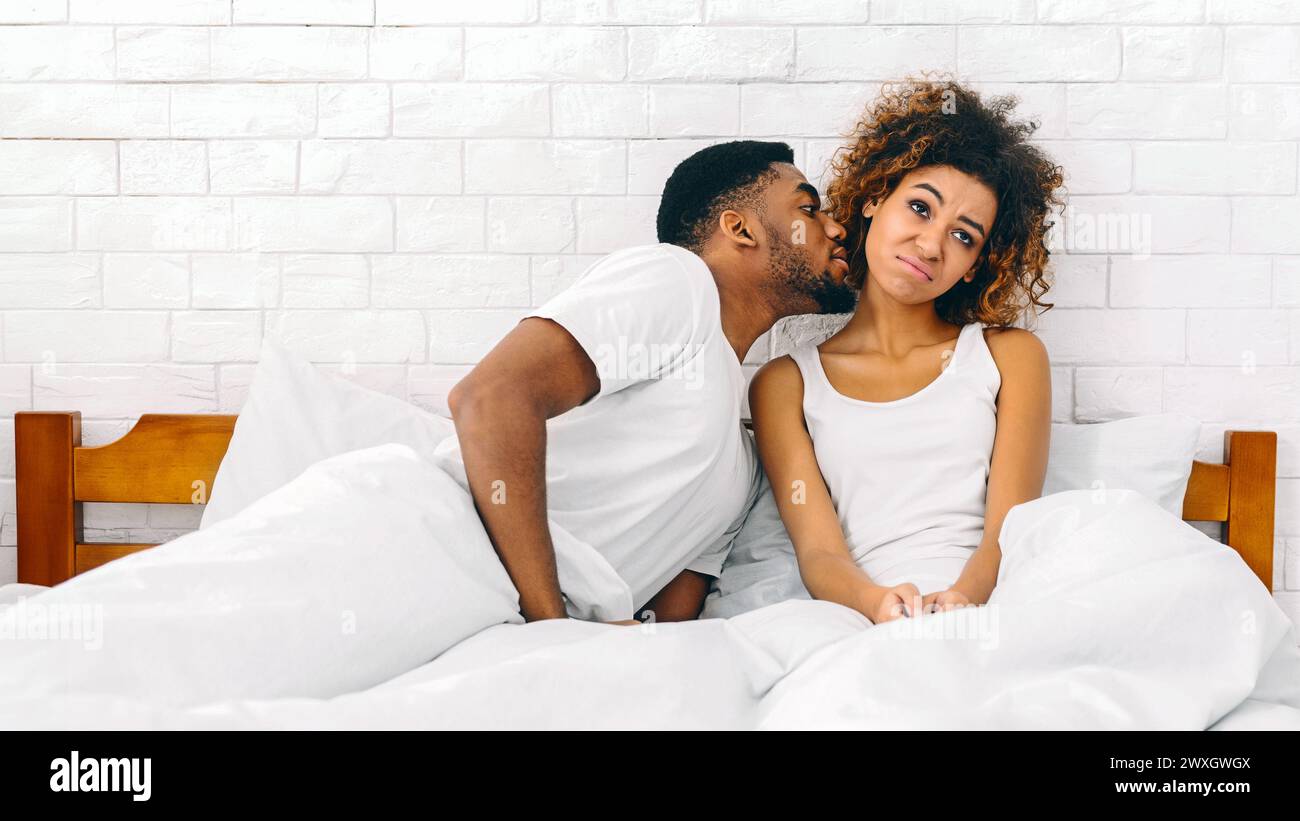 Couple cuddling in bed with white sheets Stock Photo - Alamy
