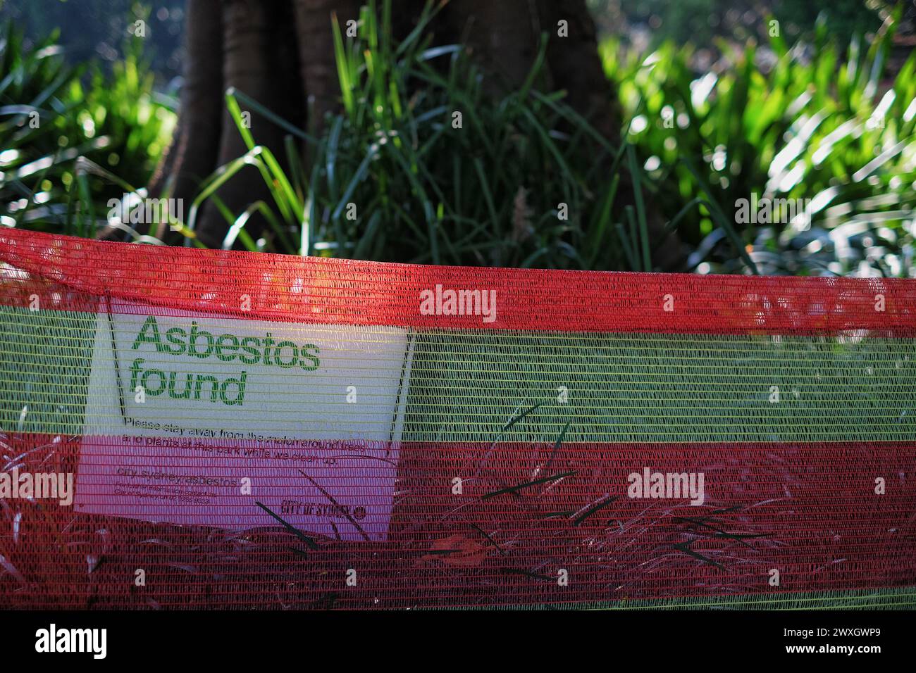 Asbestos Found sign in close up, orange & yellow hazard barrier mesh ...