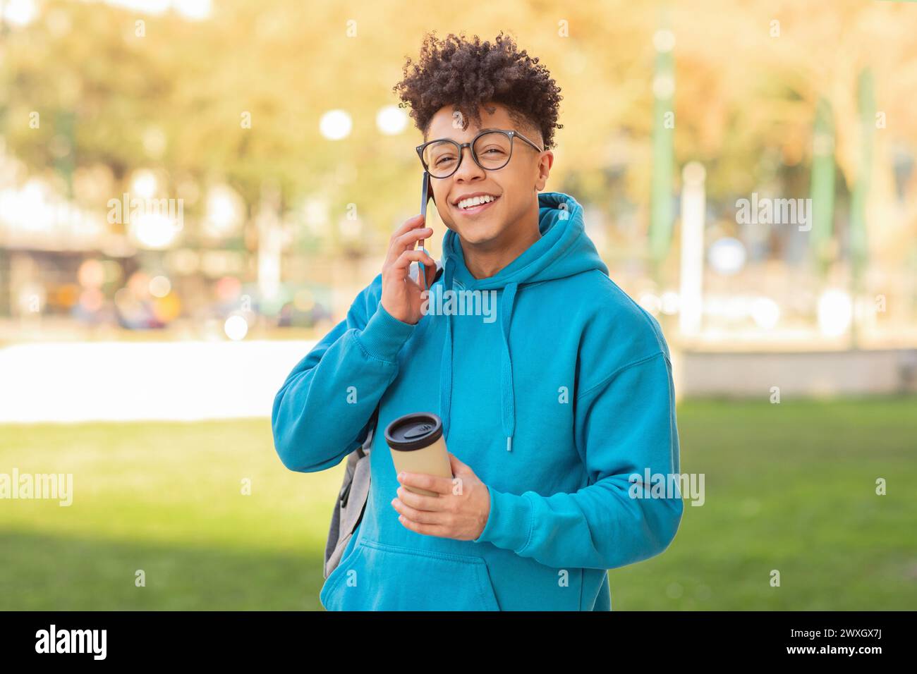 Happy student talking on phone with coffee Stock Photo - Alamy