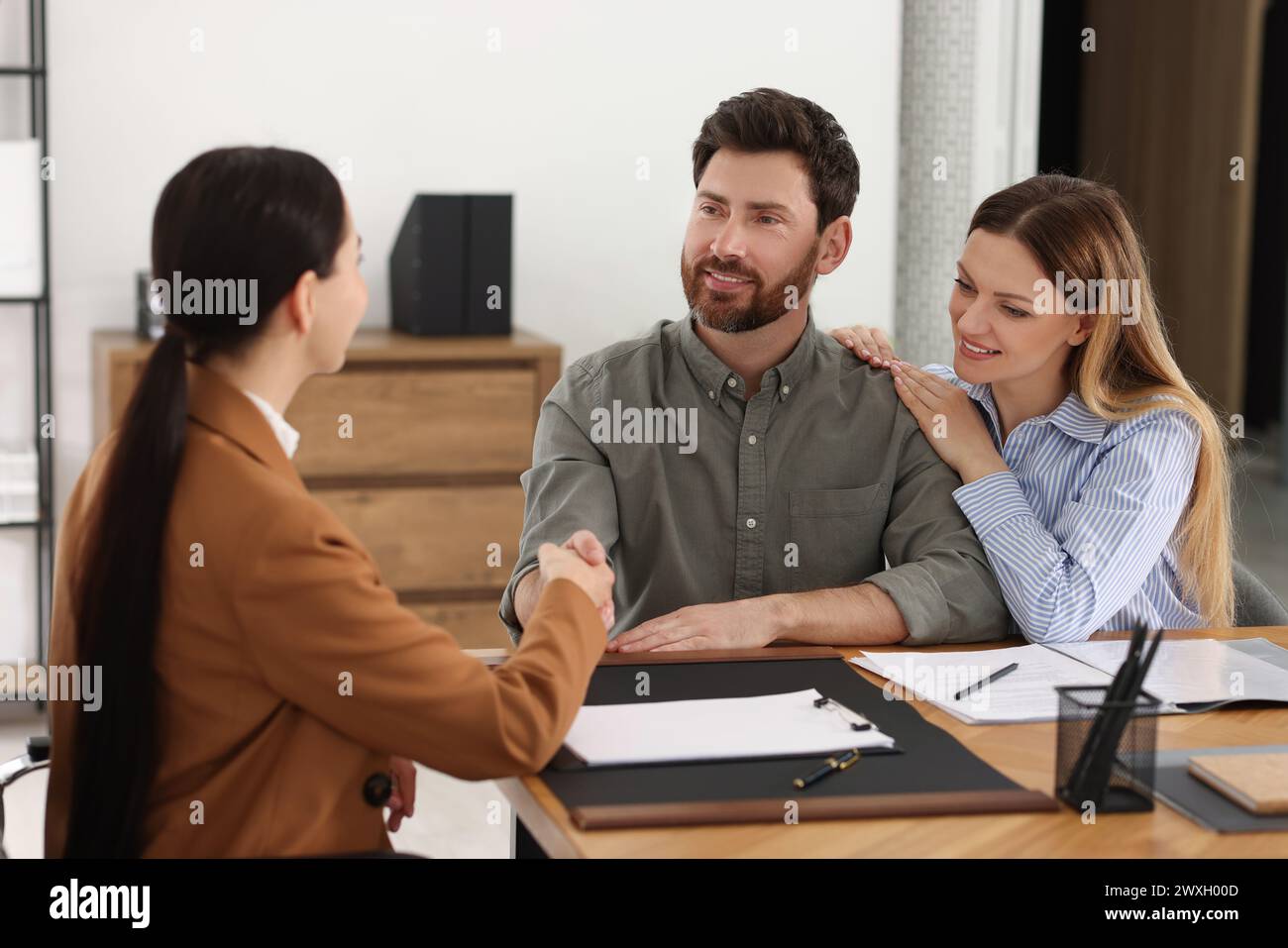 Lawyer shaking hands with clients in office Stock Photo - Alamy