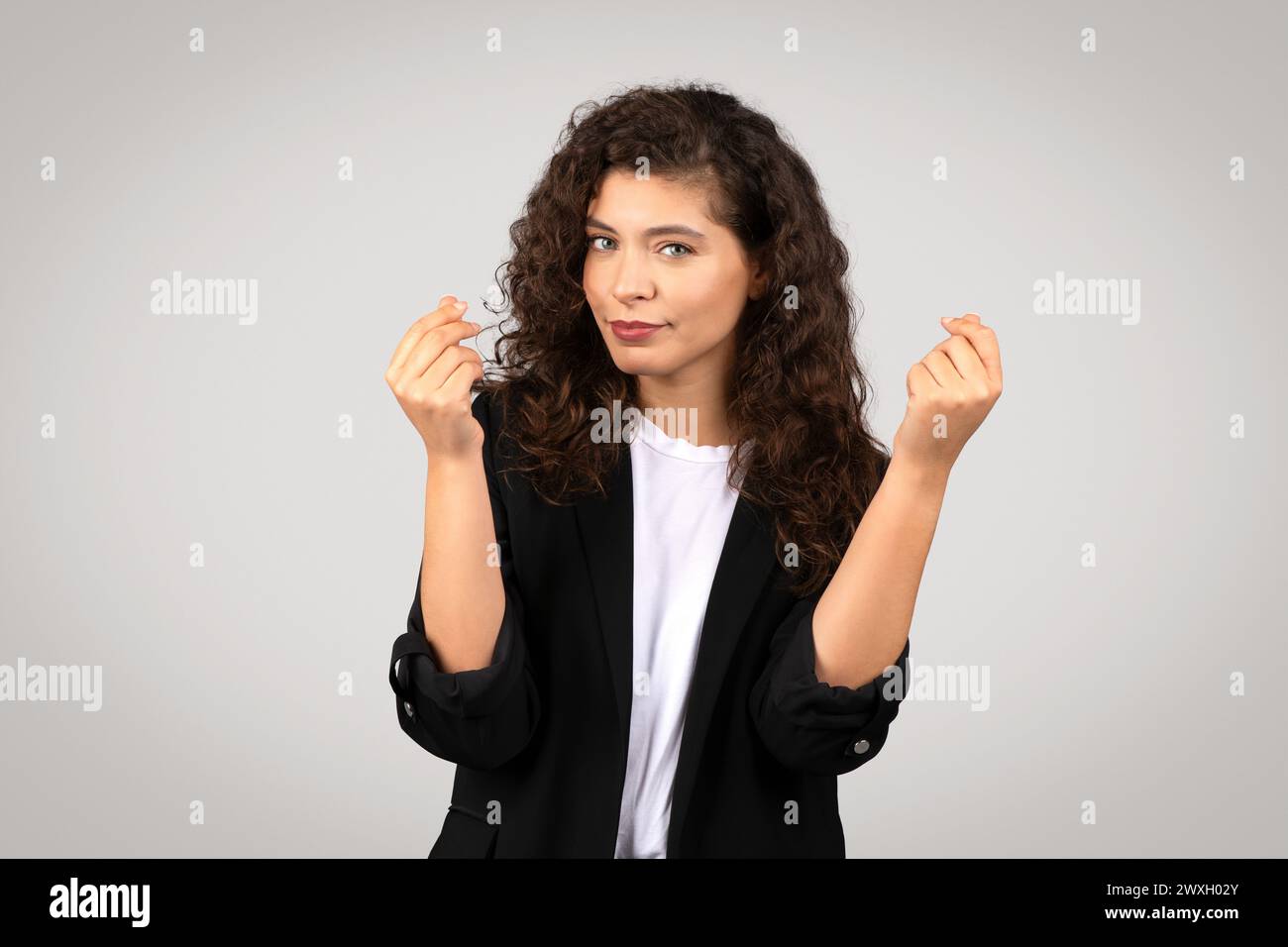 Confident woman snapping fingers in studio Stock Photo - Alamy