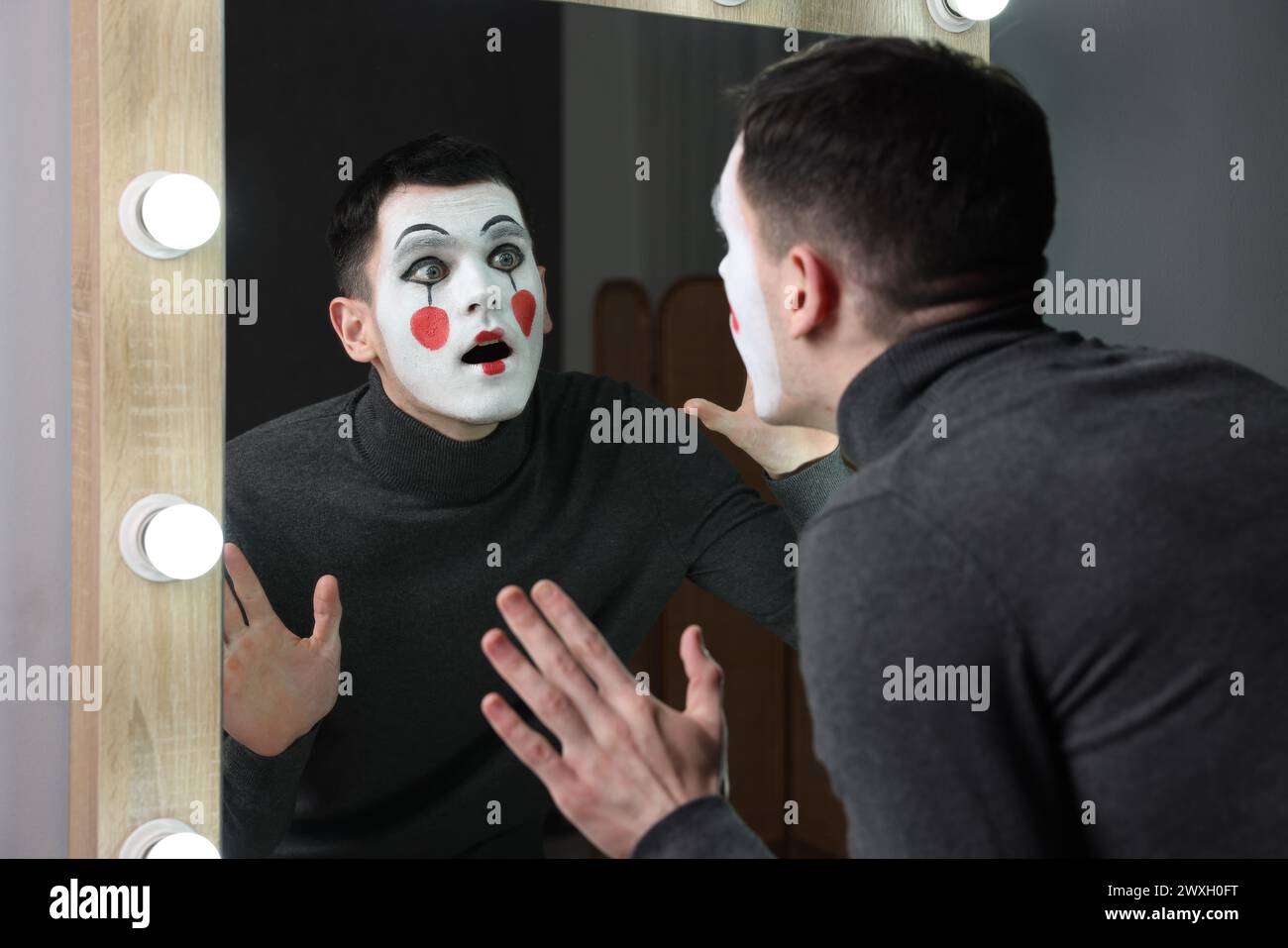 Mime artist posing near mirror in dressing room Stock Photo - Alamy