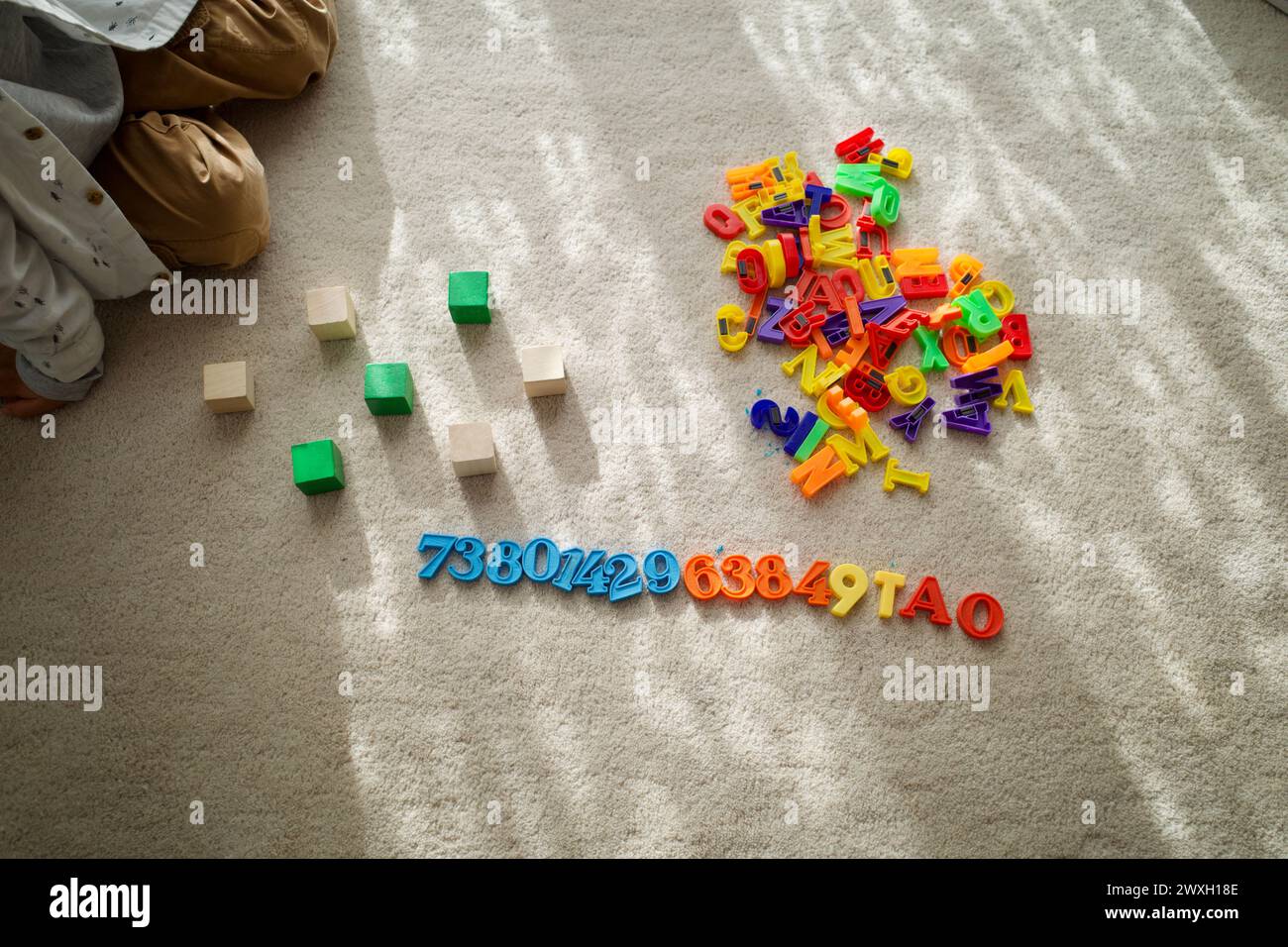 Learning by playing - a kid playing numbers and alphabet toys on a ...