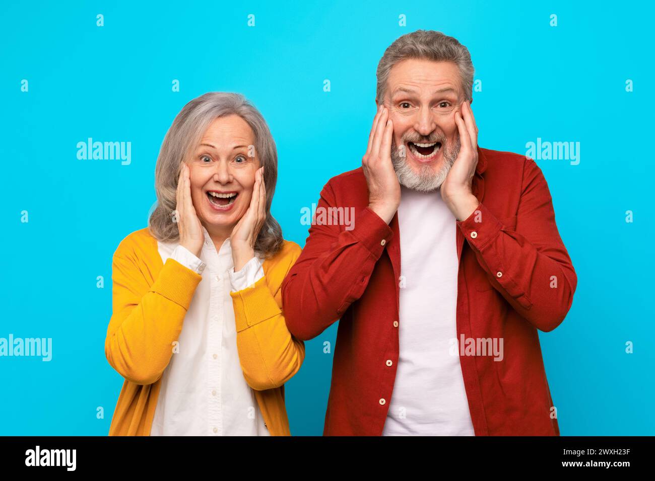 Elderly husband and wife expressing shock and surprise shouting, studio ...