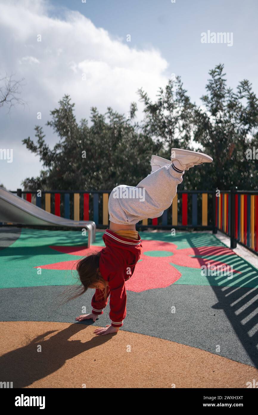Child girl doing handstand on the outdoors playground. Funny active ...