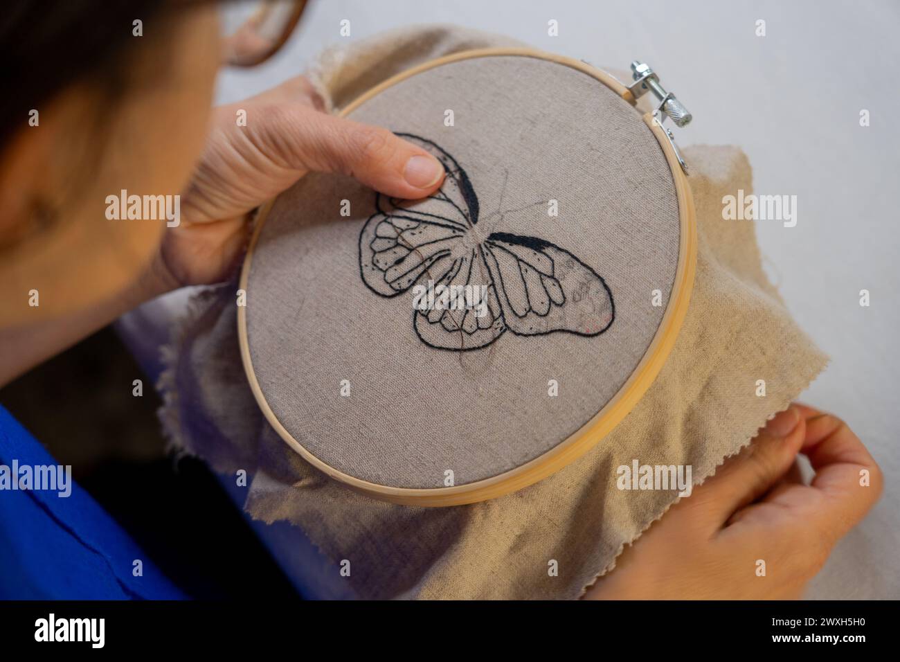 Woman embroidering a butterfly by hand Stock Photo - Alamy