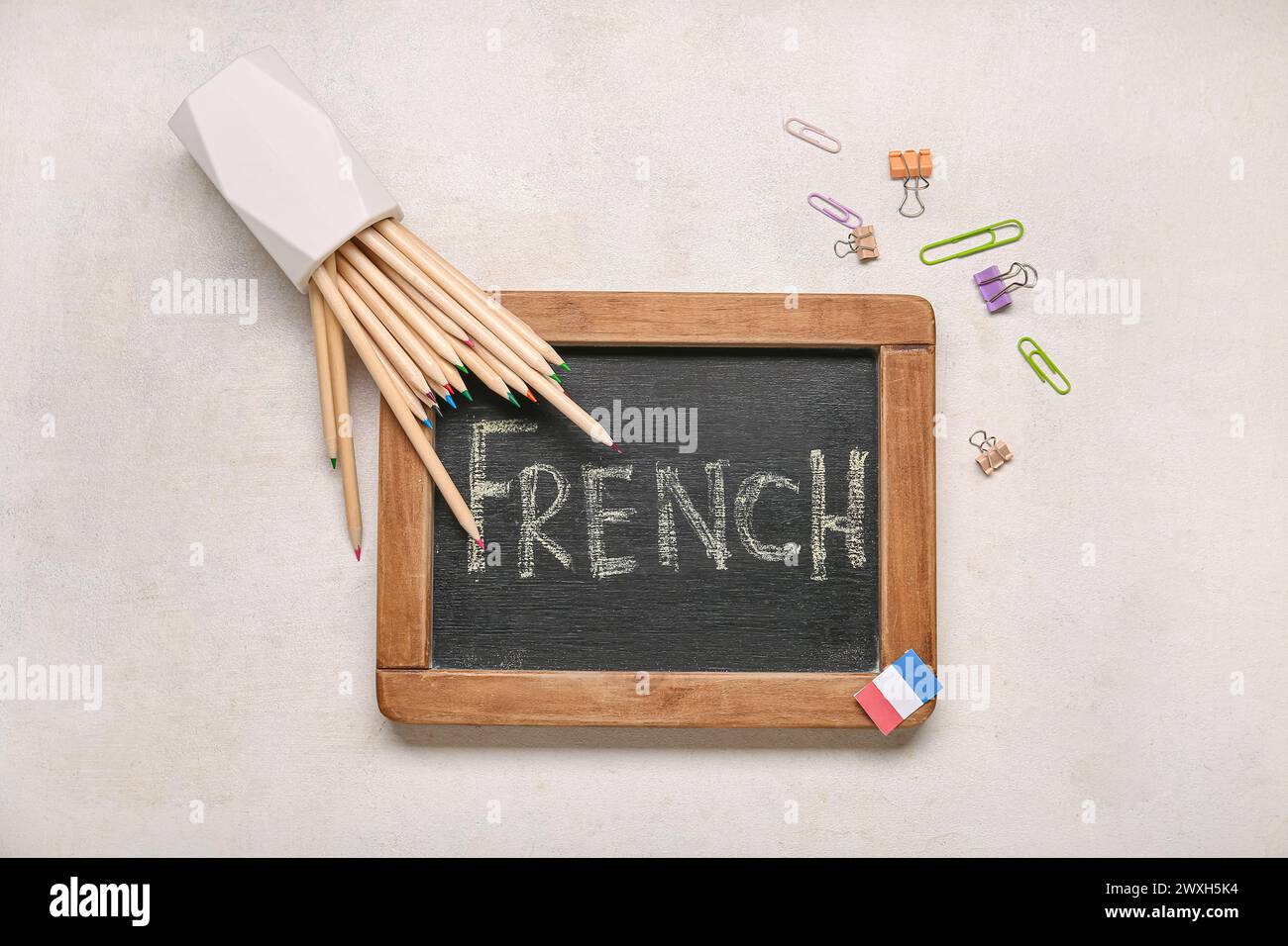 Chalkboard with word FRENCH and stationery on light background Stock ...