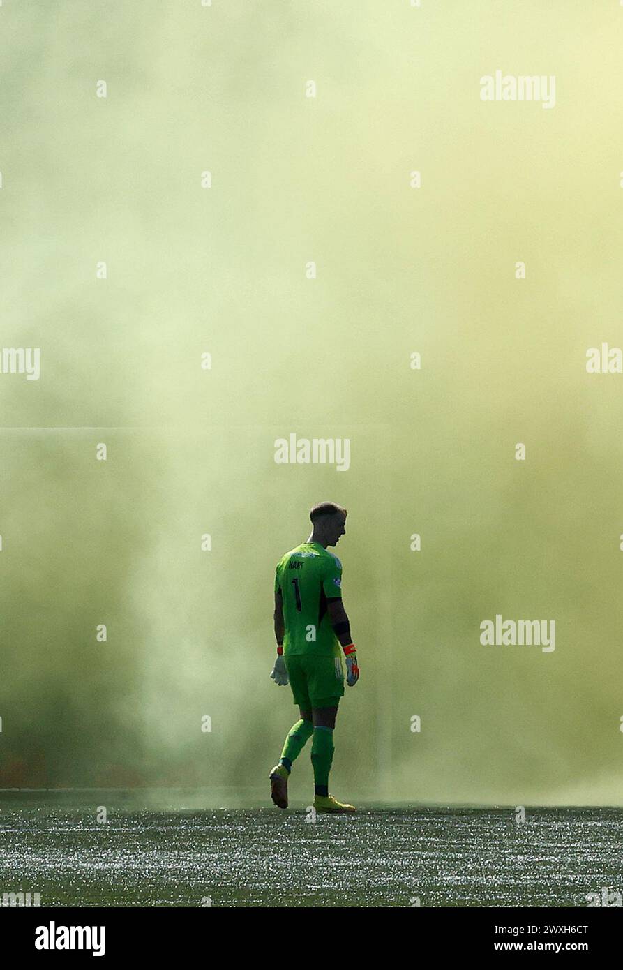 Celtic goalkeeper Joe Hart watches on as smoke appears from flares in ...
