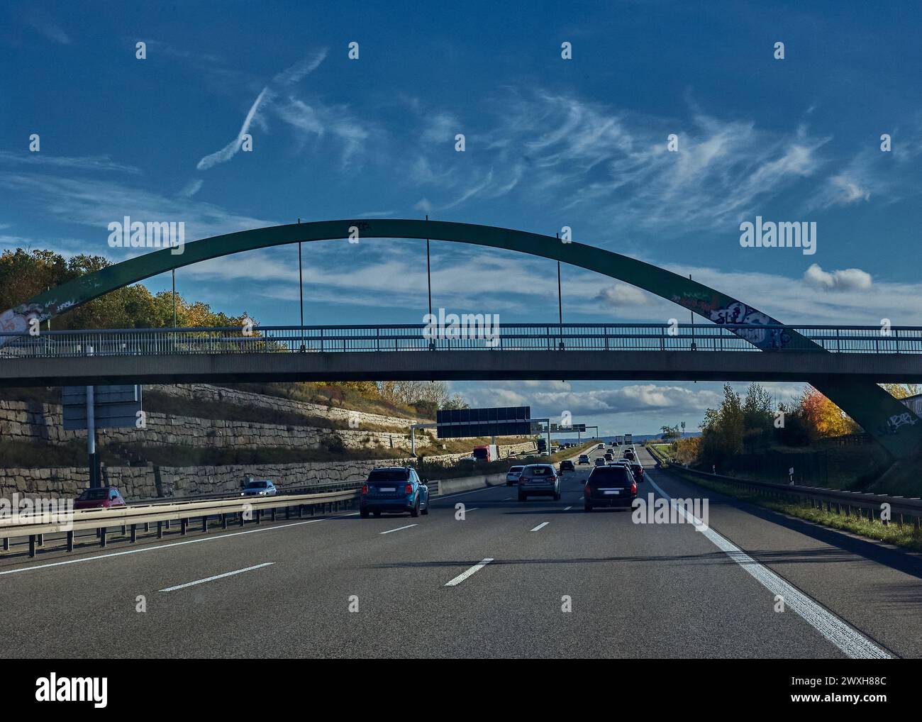 The arch of the bridge over the road stretching into the distance ...