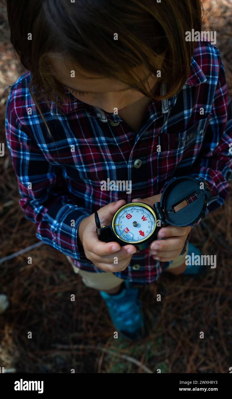 Child in nature looking at a compass Stock Photo - Alamy