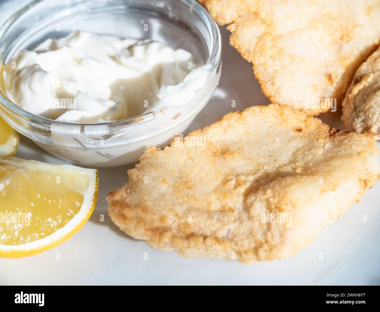 Plate with two food portions, one half served with a spoon, on a white ...