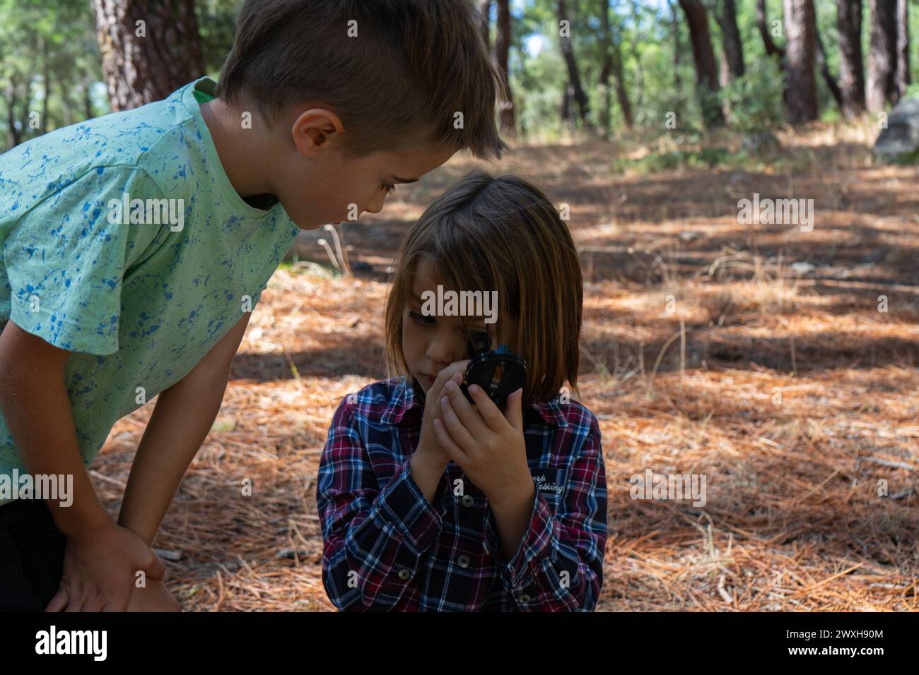 Two 7-year-old looking at a compass in nature Stock Photo - Alamy