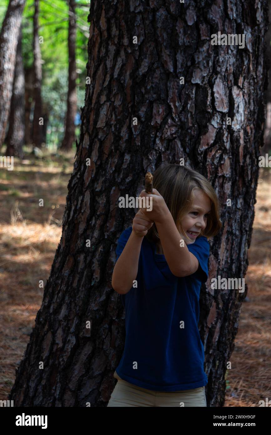 Child playing with a stick in the woods Stock Photo - Alamy