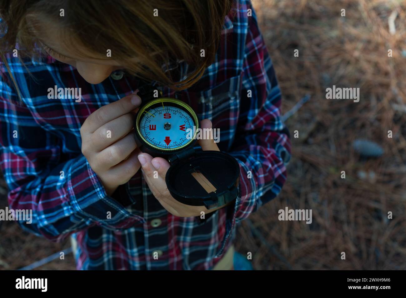 Child looking at a compass in nature Stock Photo - Alamy
