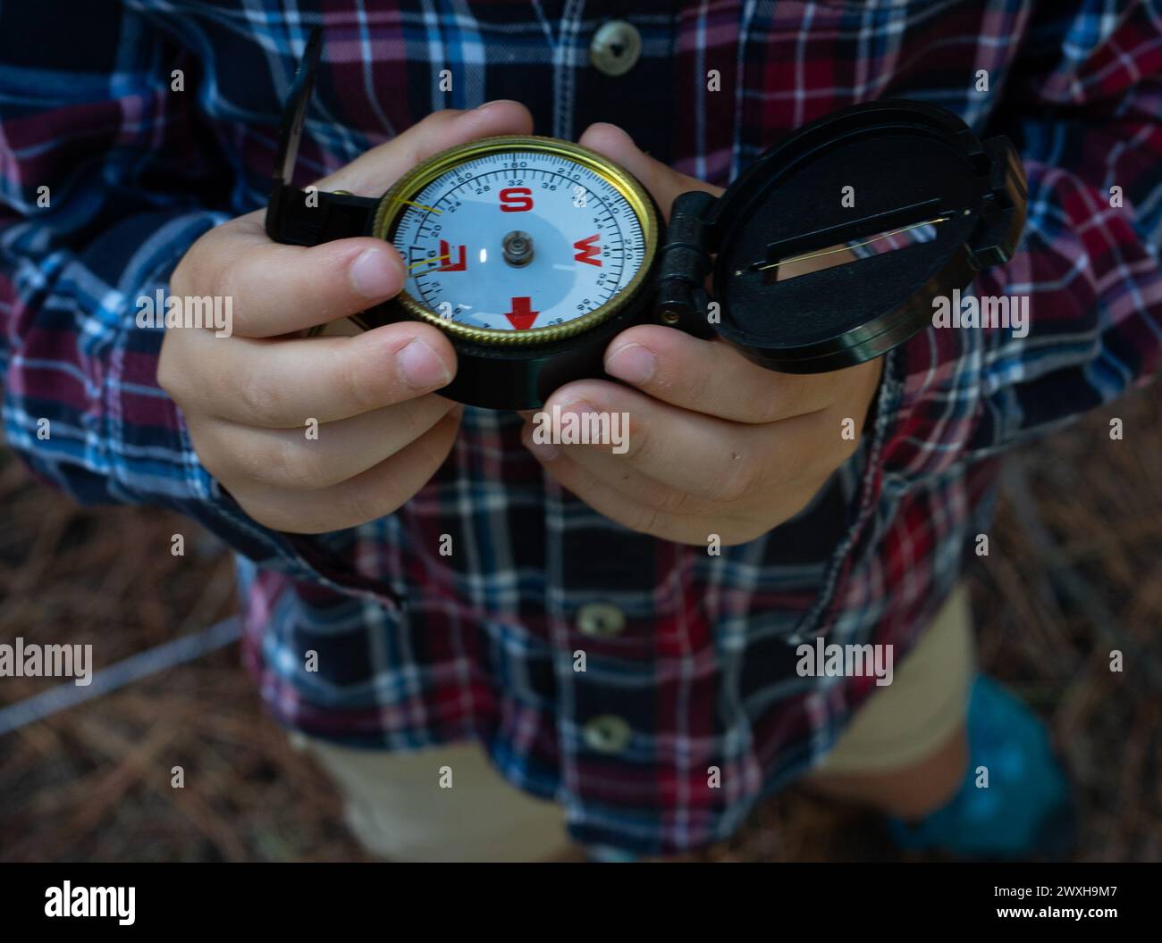 Child's hands with a compass in nature Stock Photo - Alamy